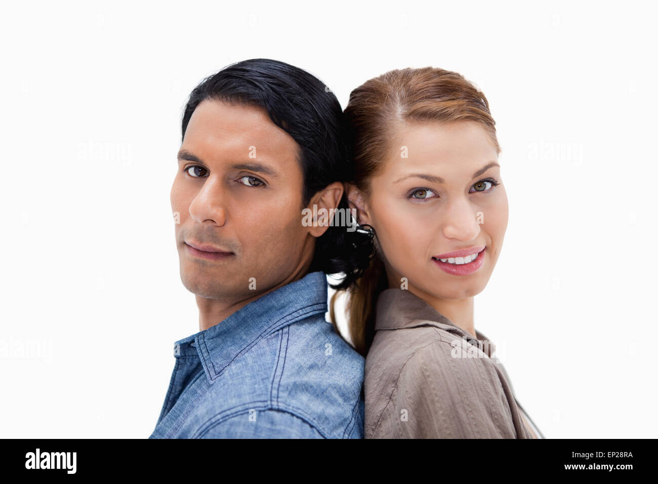 Side view of young couple standing back to back Stock Photo - Alamy