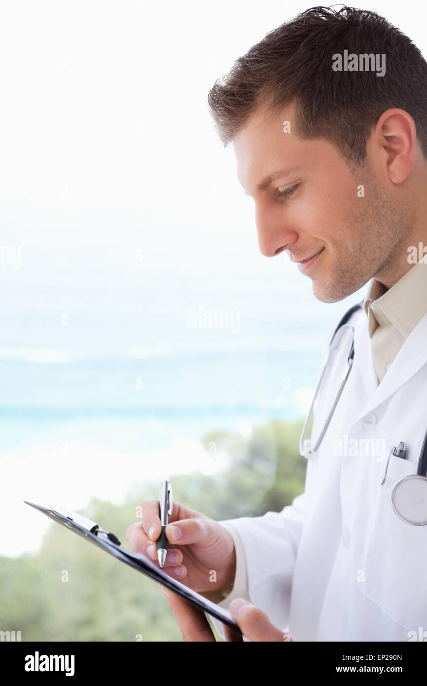 Side view of doctor taking notes Stock Photo - Alamy