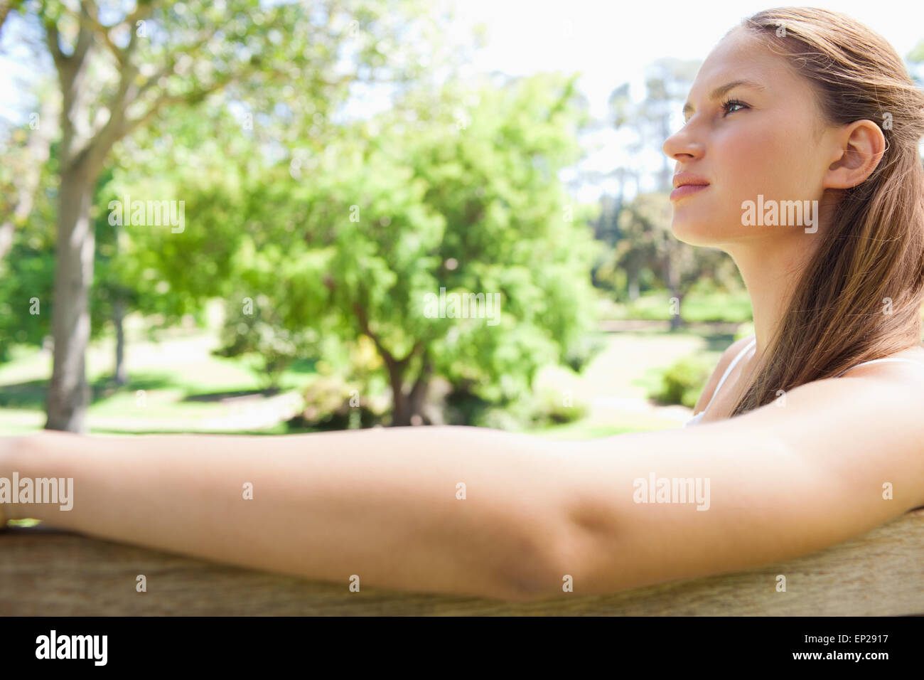 Side view of a woman sitting on a park bench Stock Photo - Alamy