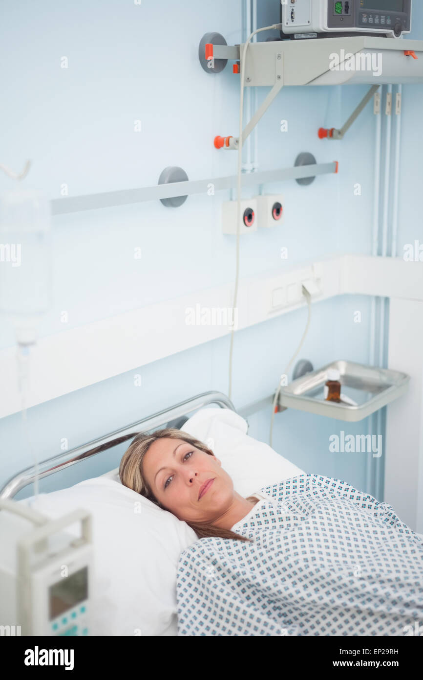 Female patient looking at camera while lying on a bed Stock Photo - Alamy