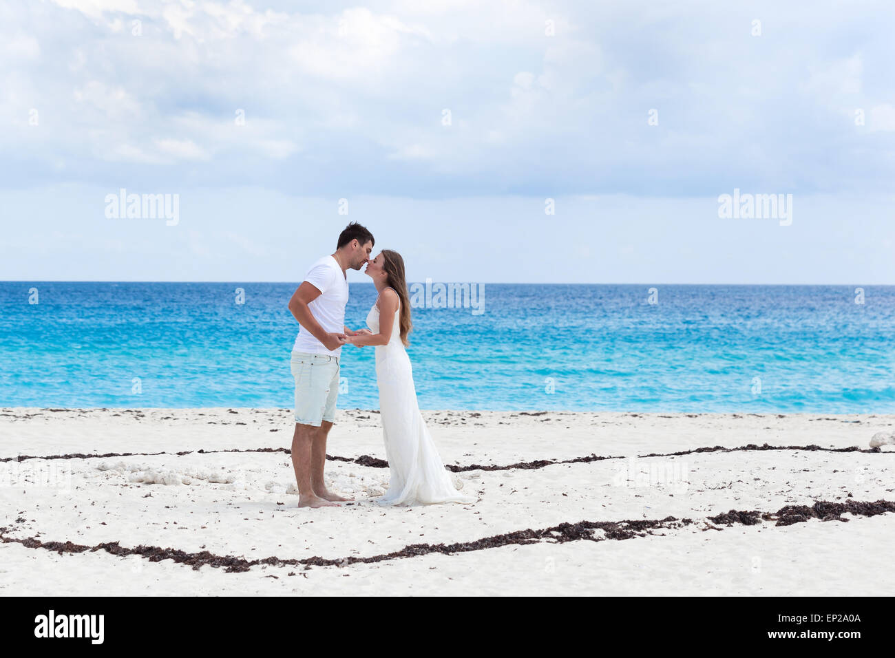 Beautiful young couple kissing on white sandy beach Stock Photo - Alamy