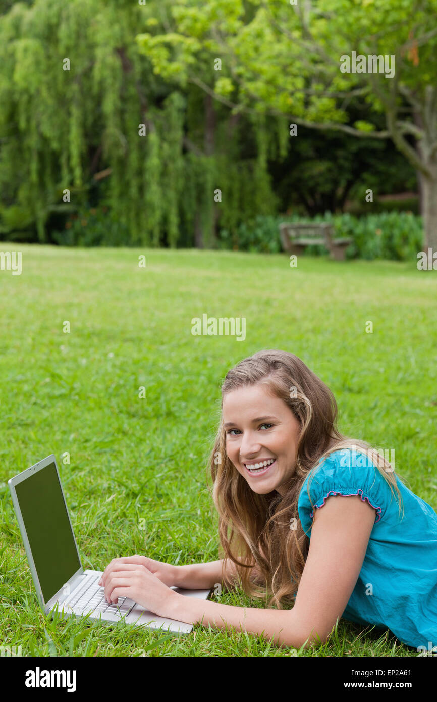Young girl laughing while typing on her laptop Stock Photo - Alamy