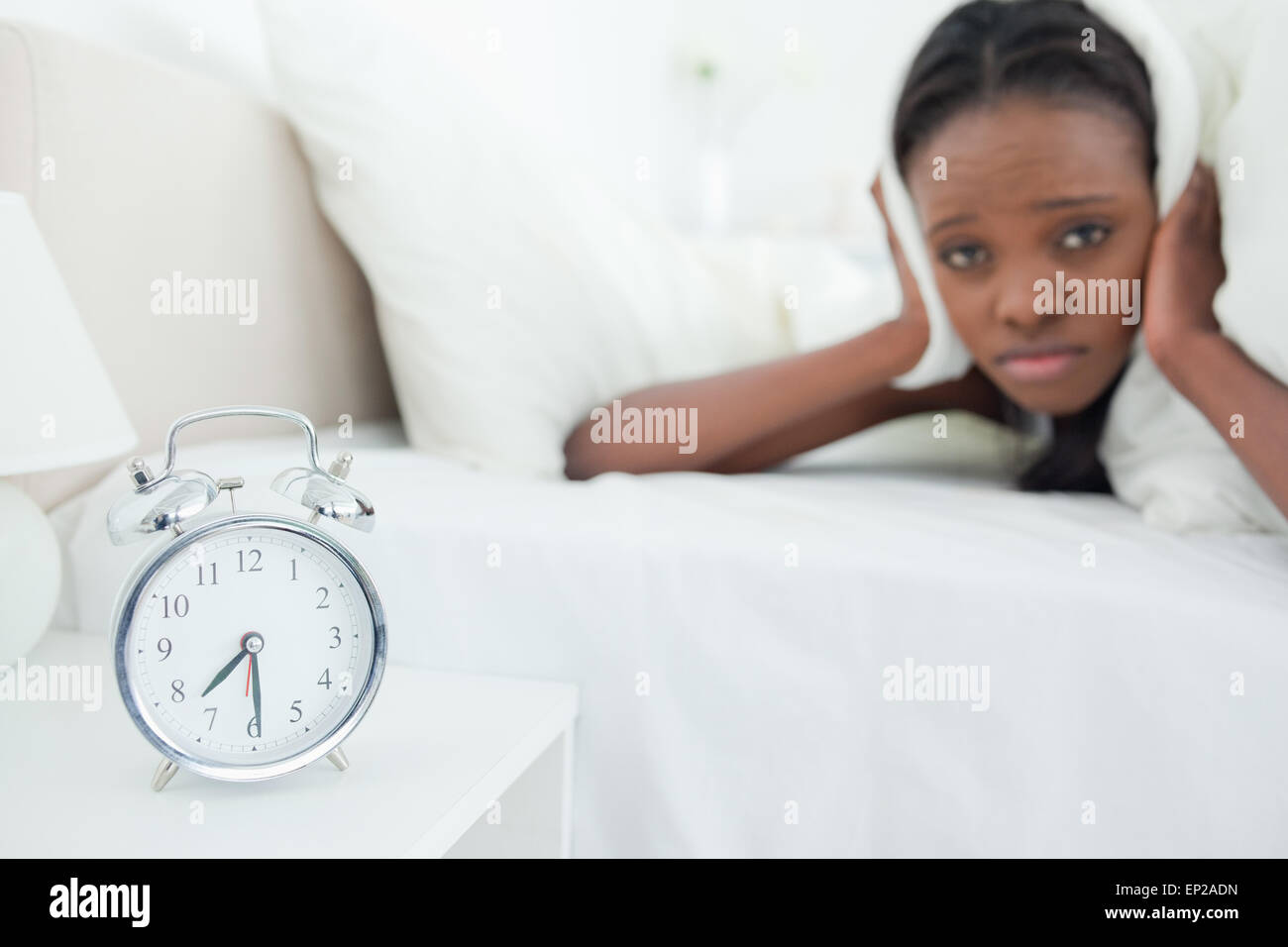 Cute woman being awakened by her alarm clock Stock Photo - Alamy
