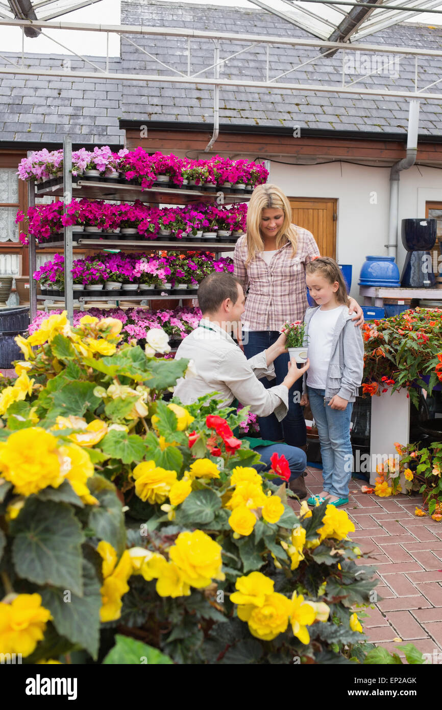 Woman and child taking a flower pot from employee Stock Photo - Alamy