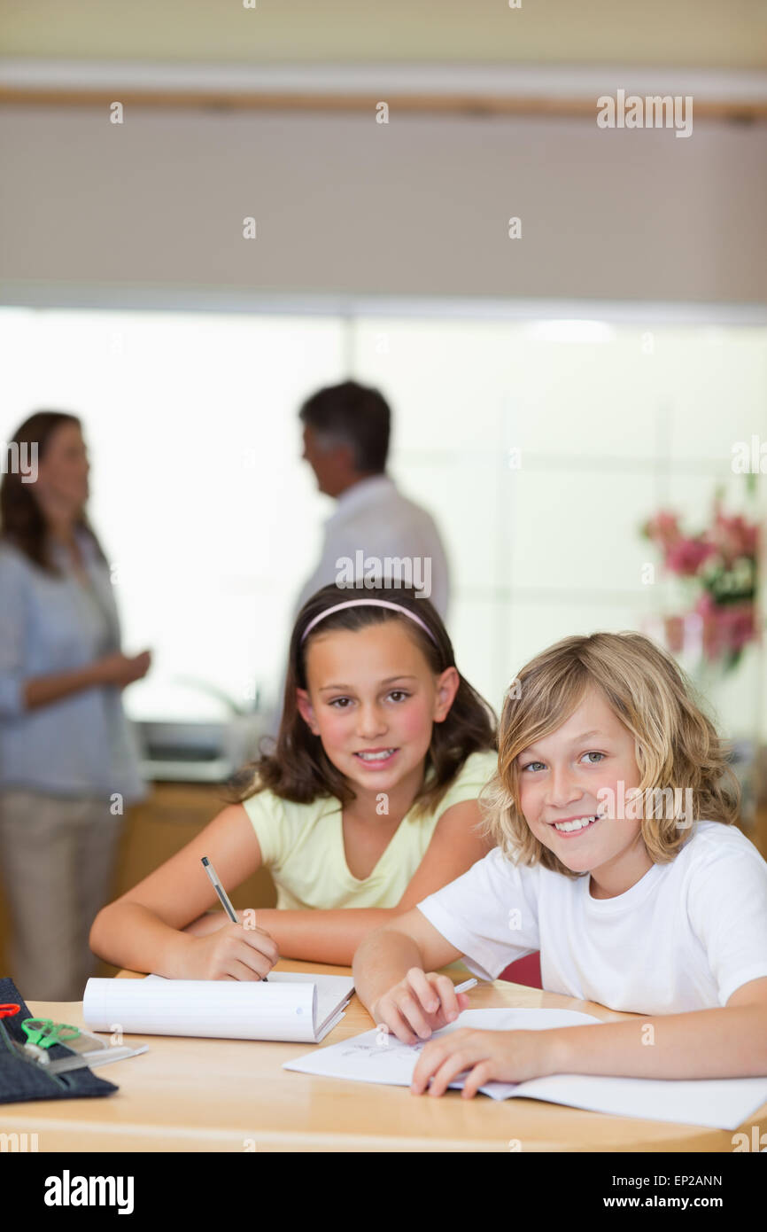 Children doing homework with their parents behind them Stock Photo - Alamy