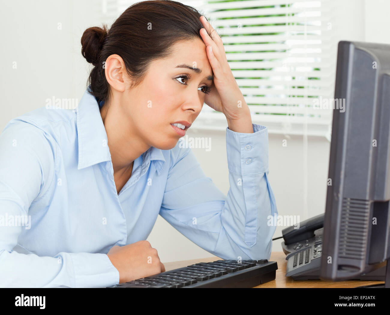 Attractive upset woman looking at a computer screen while sitting Stock ...