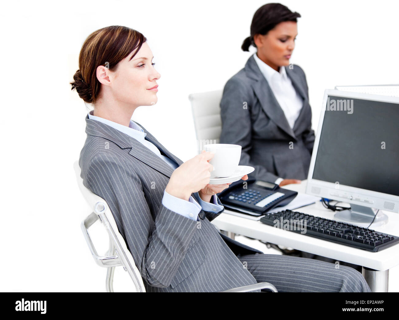 Busy female business partners drinking coffee while having a break in ...