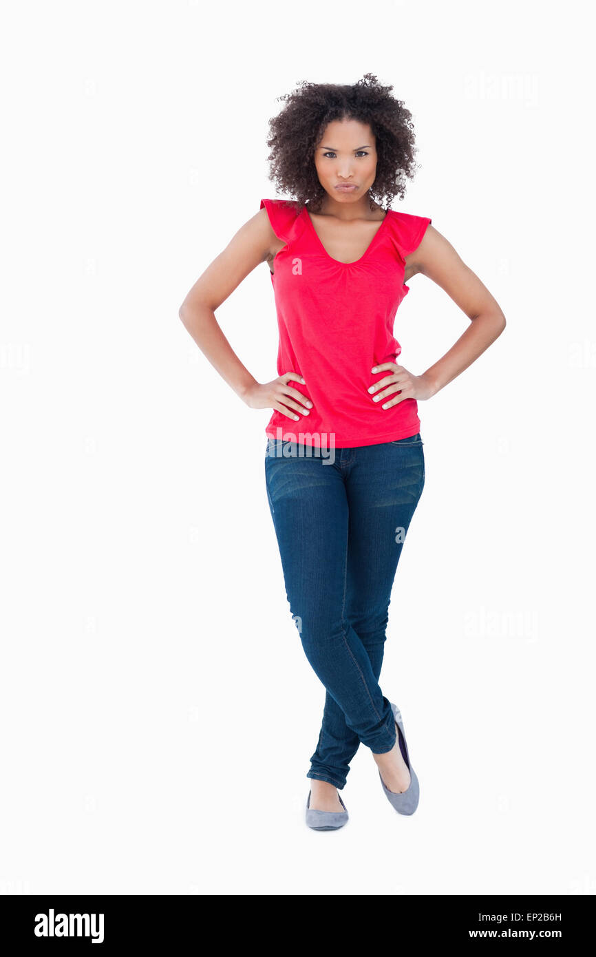 Serious young woman placing her hands on her hips Stock Photo - Alamy