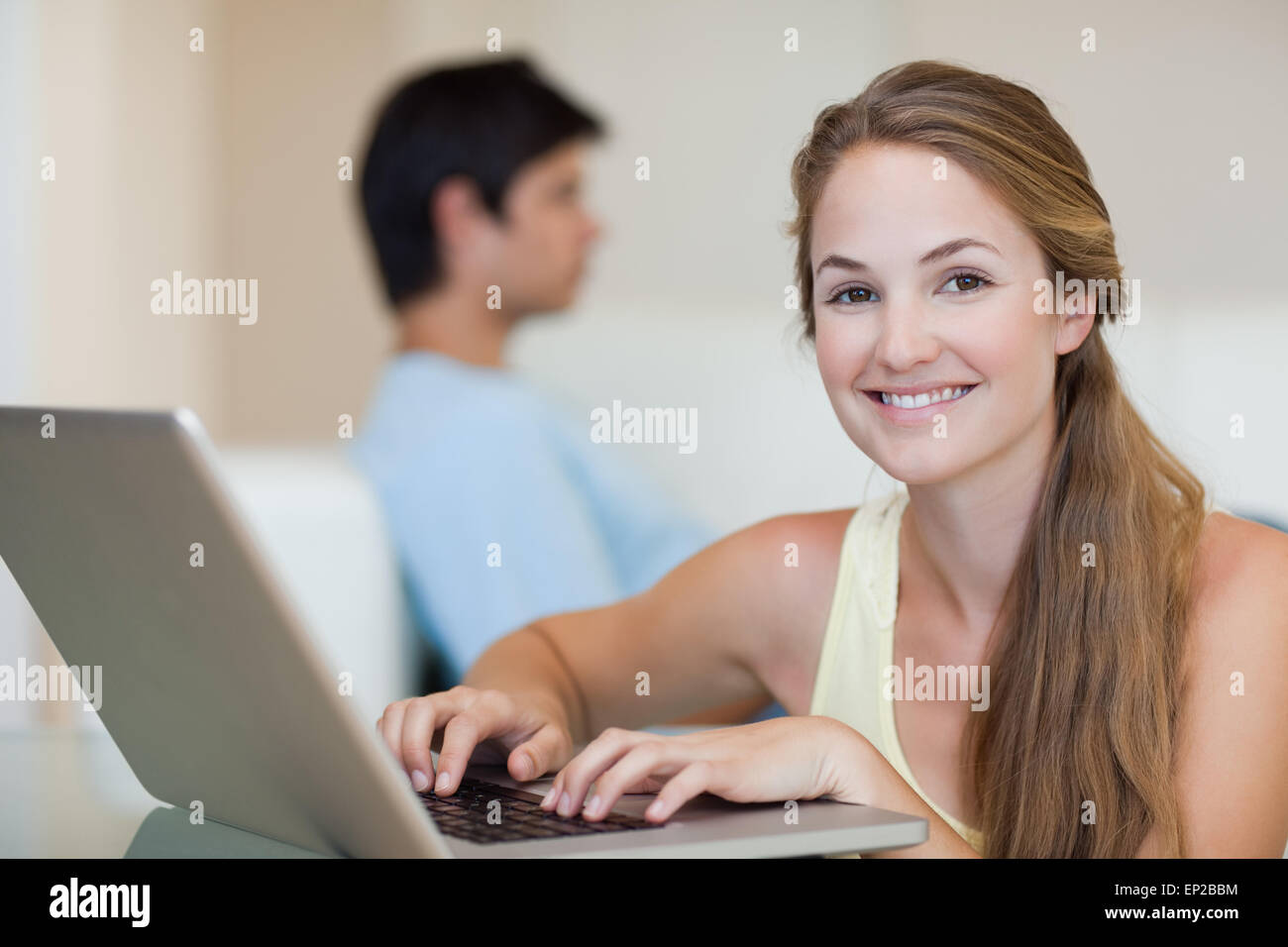 Woman using a notebook while her fiance is sitting on a sofa Stock ...