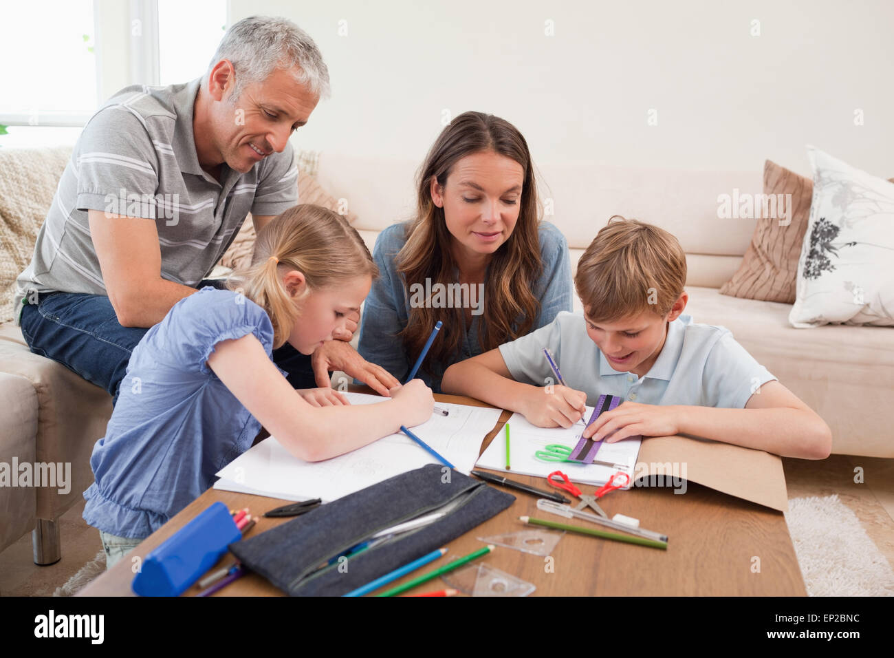 Parents helping their children to do their homework Stock Photo - Alamy