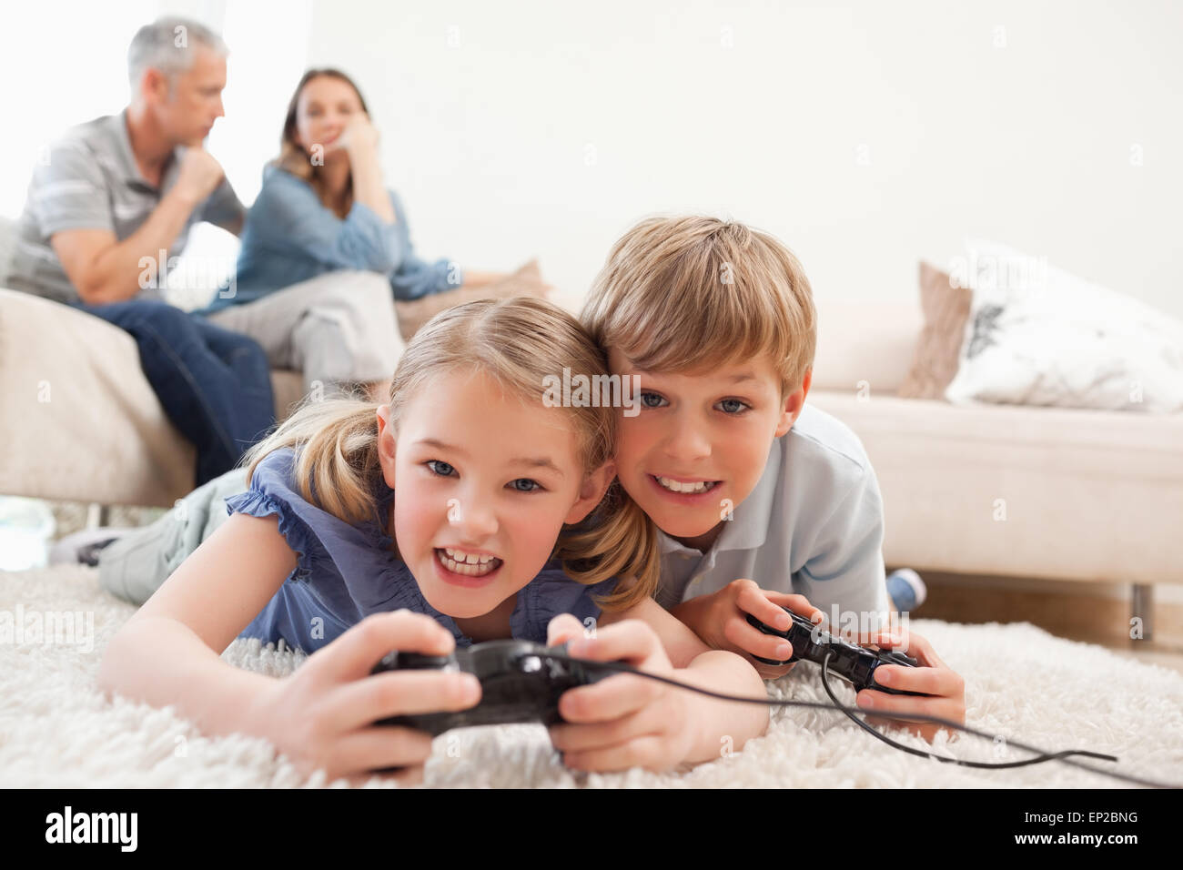 Cheerful children playing video games with their parents on the Stock ...