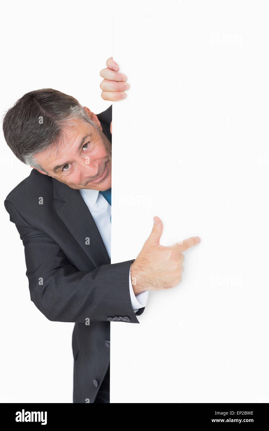 Man pointing to whiteboard he is hiding behind Stock Photo - Alamy