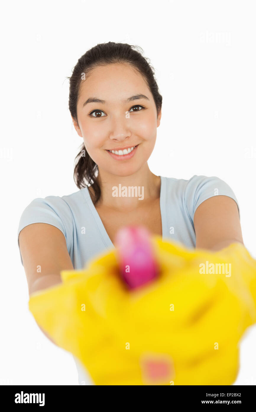 Smiling woman pointing spray bottle at the camera Stock Photo - Alamy