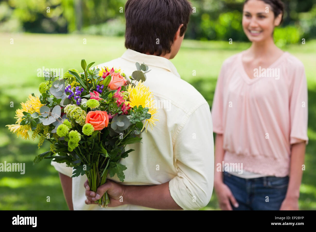 Man about to present a bouquet of flowers to his friend Stock Photo - Alamy