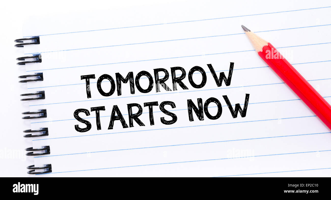 Tomorrow Starts Now Text written on notebook page, red pencil on the ...
