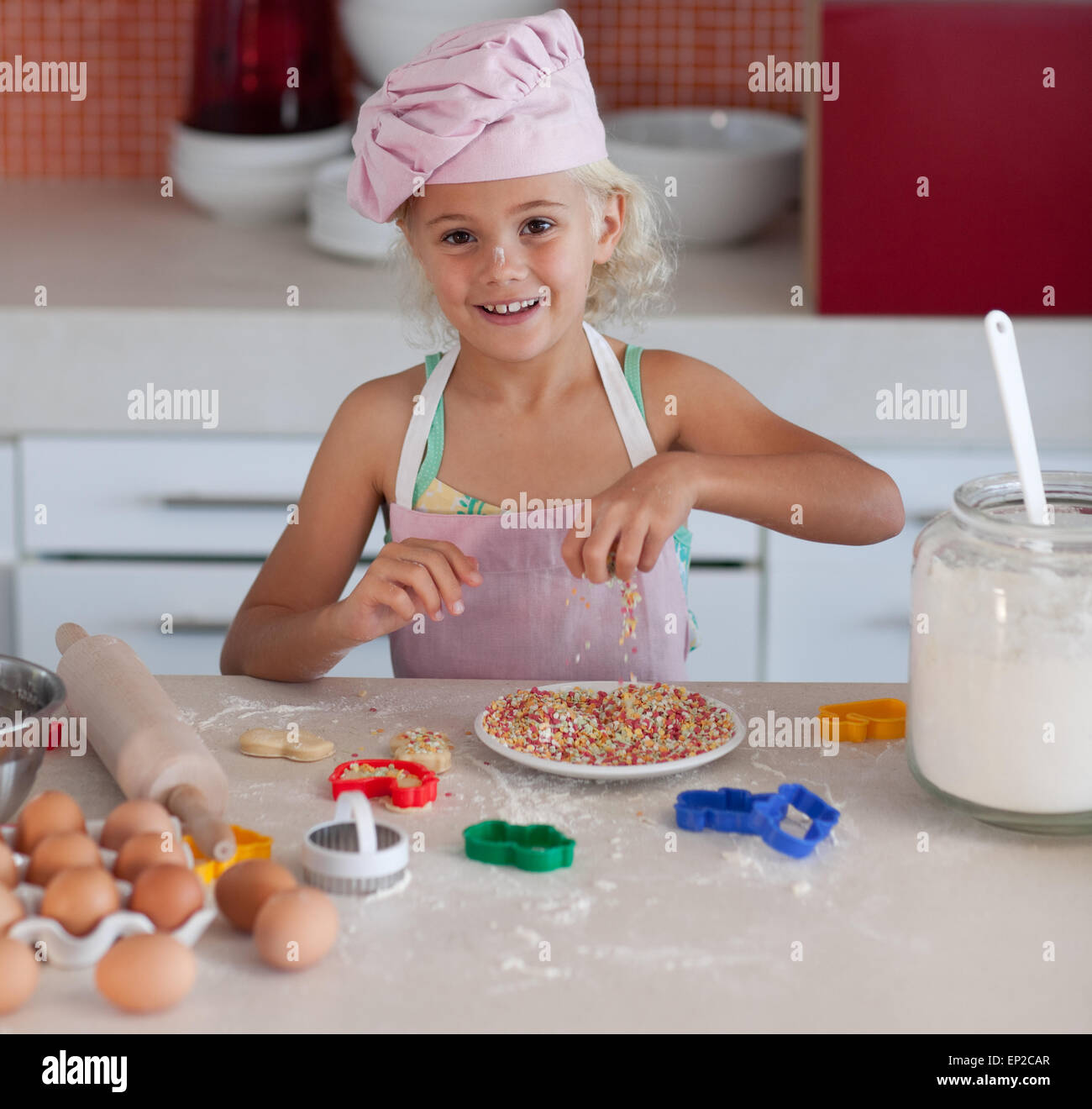 Merry little girl baking biscuit Stock Photo - Alamy