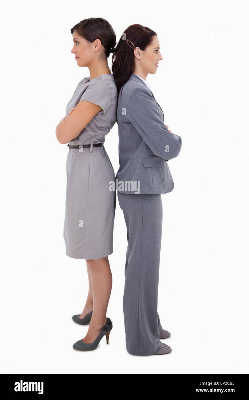 Businesswomen with arms folded standing back on back Stock Photo - Alamy