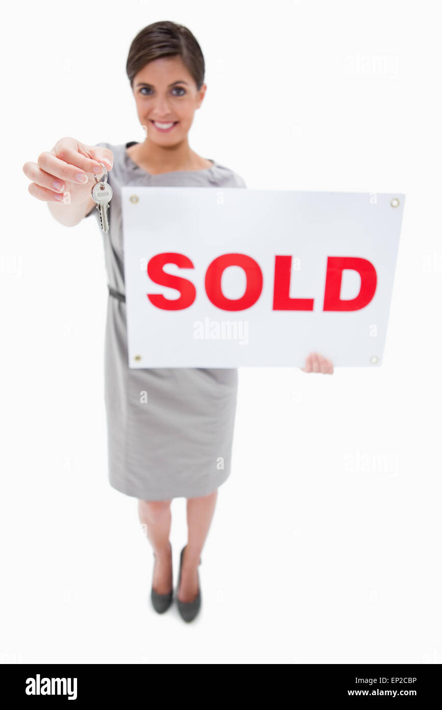 Real estate agent with sold sign handing over key Stock Photo - Alamy