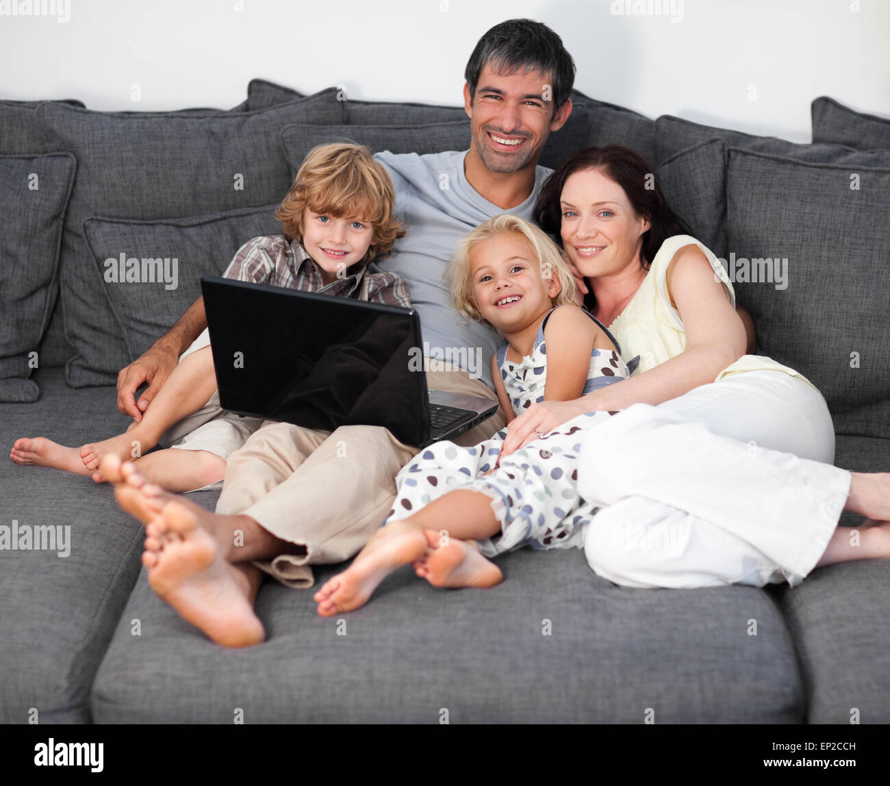 Parents and kids using a laptop Stock Photo - Alamy