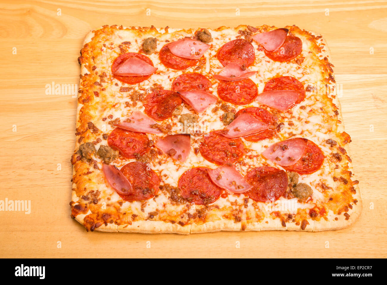 A square toasted meat pizza on wood table Stock Photo - Alamy