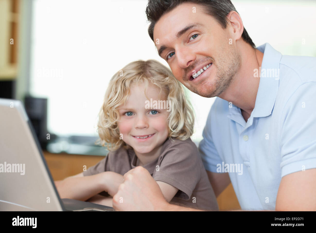 Smiling father and son with notebook Stock Photo - Alamy