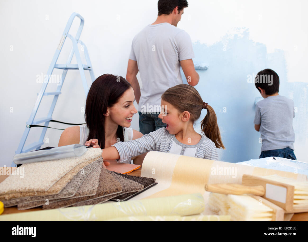 Smiling family decorating their new home Stock Photo - Alamy