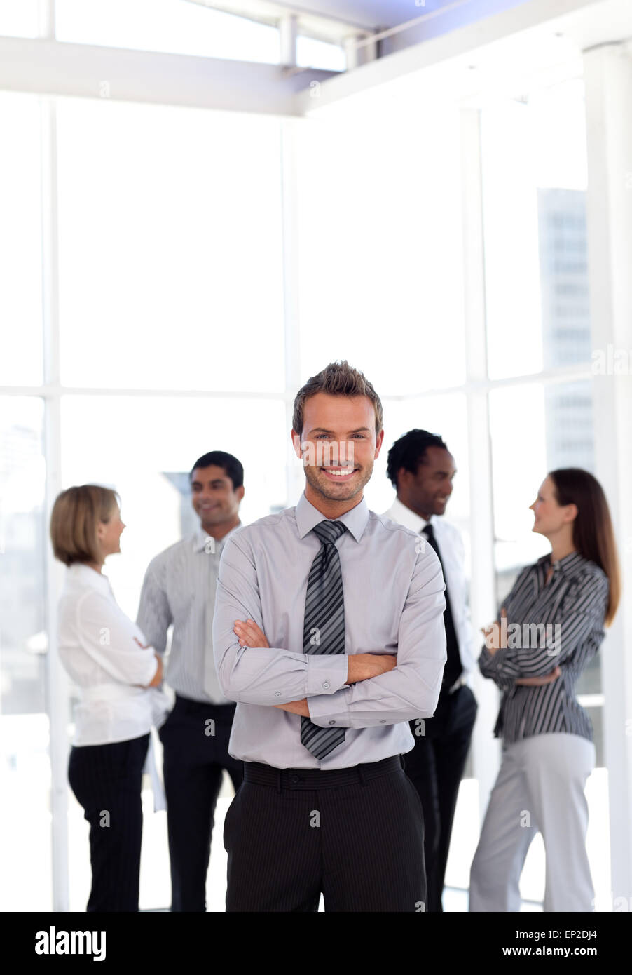 Charming business manager standing at the camera with his team Stock ...