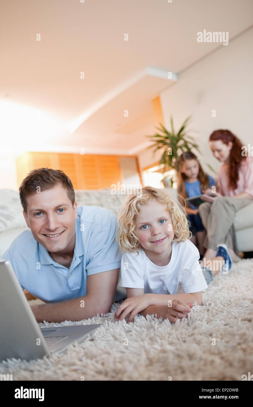 Father and son using internet on the floor Stock Photo - Alamy
