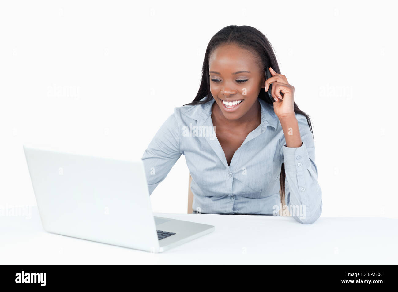 Businesswoman making a phone call while using a notebook Stock Photo ...