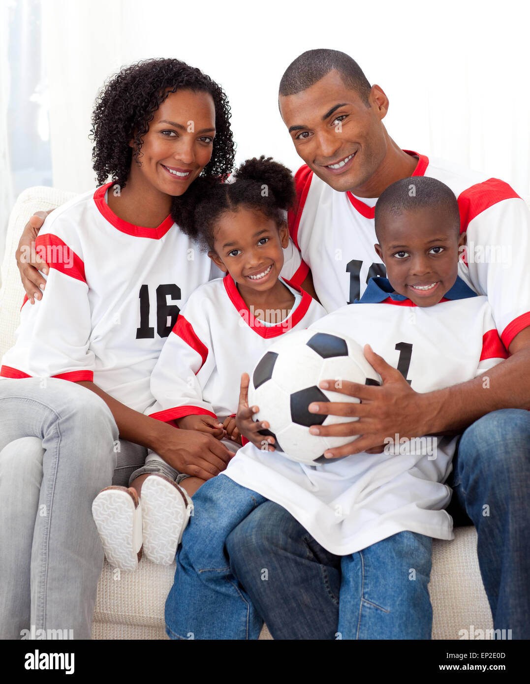 Smiling family holding a soccer ball Stock Photo - Alamy