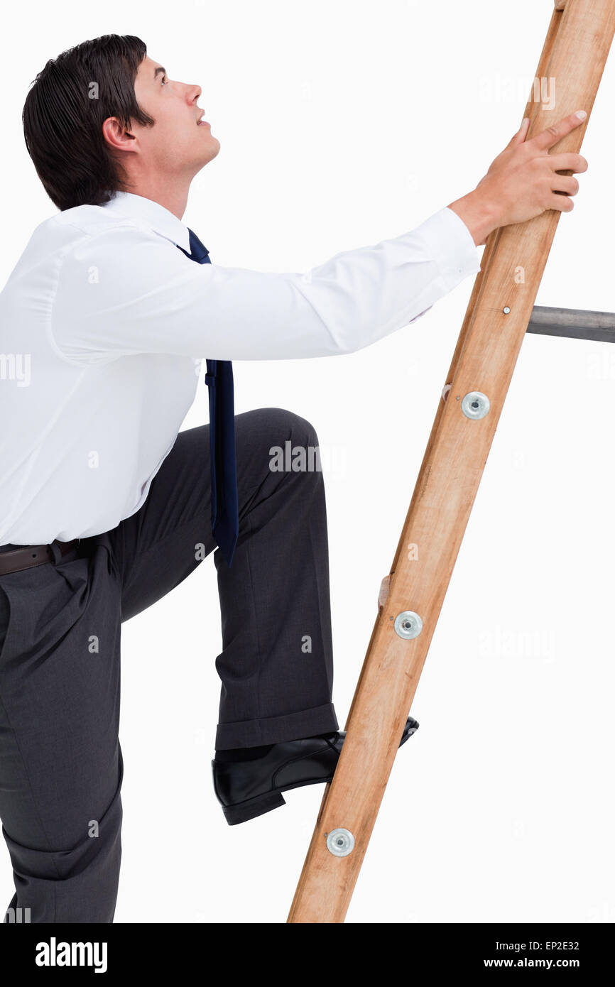 Side view of young tradesman climbing a ladder Stock Photo - Alamy