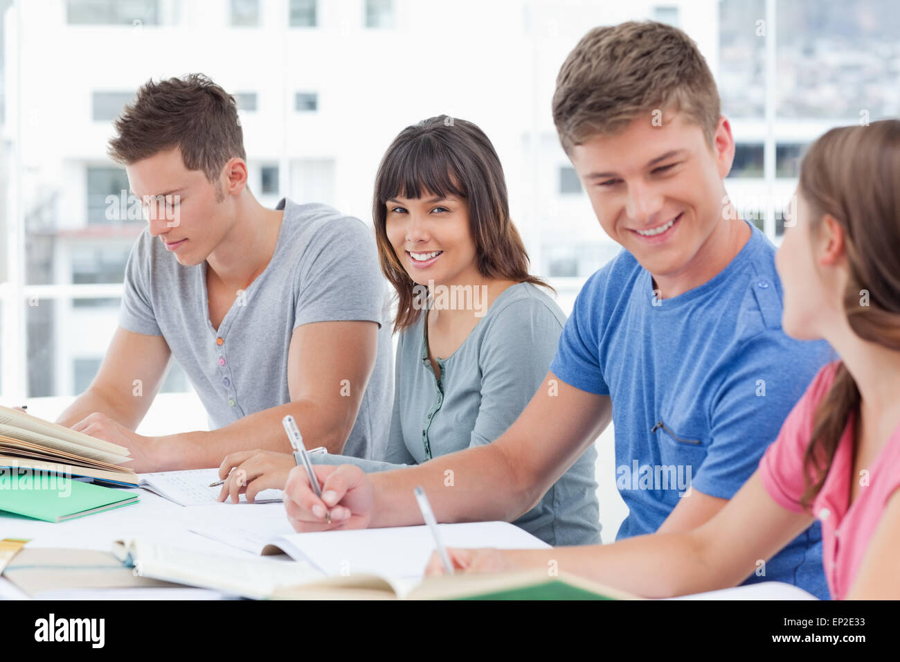 A Girl Looks Into The Camera Smiling As The Other Friends Help Each