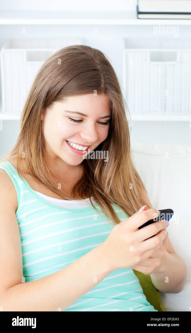 Laughing young woman writing a text message Stock Photo - Alamy