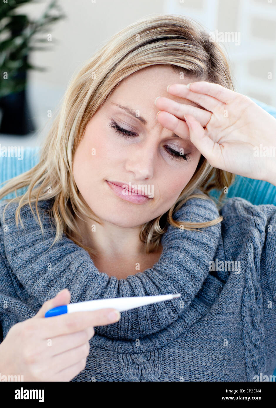 Attentive woman taking her sick tempretaure Stock Photo - Alamy