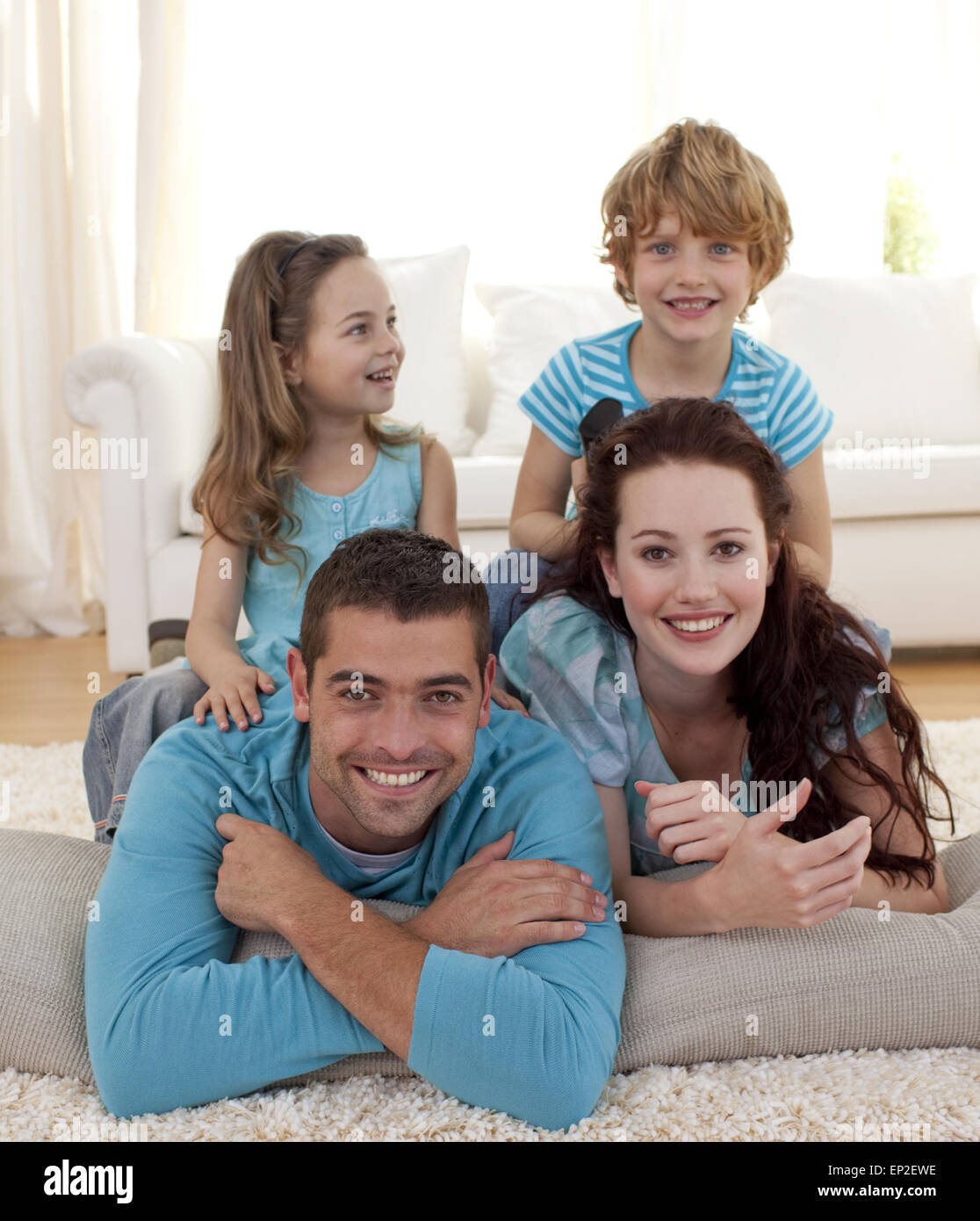 Parents, daughter and son on floor in living-room Stock Photo - Alamy