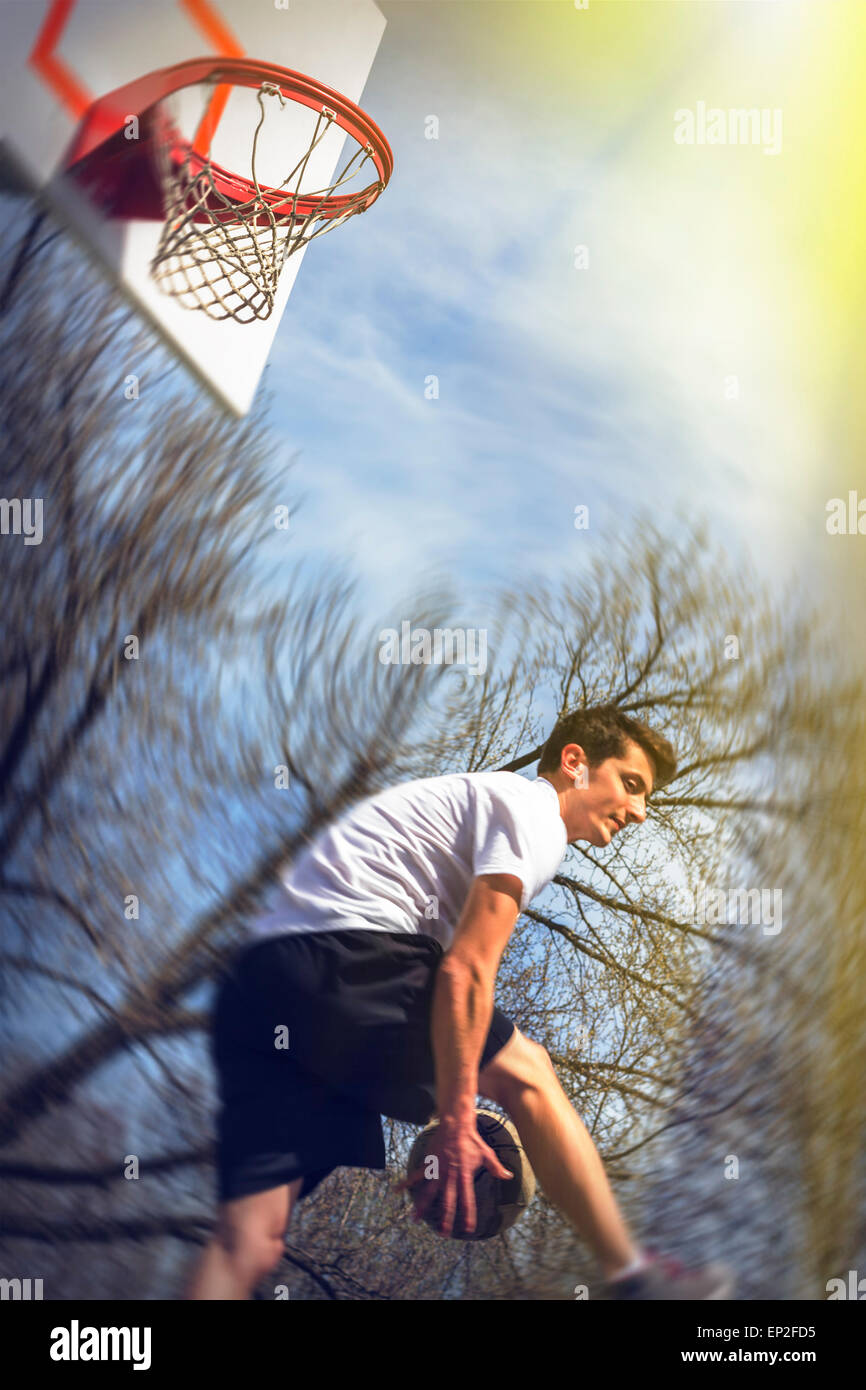 Male athlete puts basketball between his legs after rebound Stock Photo ...