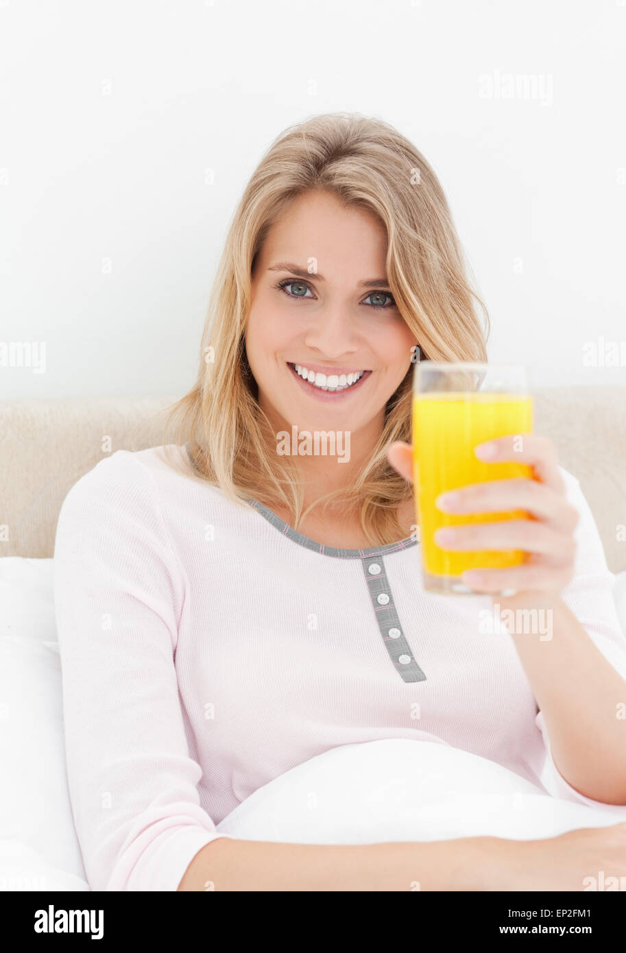 Close up, Woman looking forward smiling while holding up a glass of ...