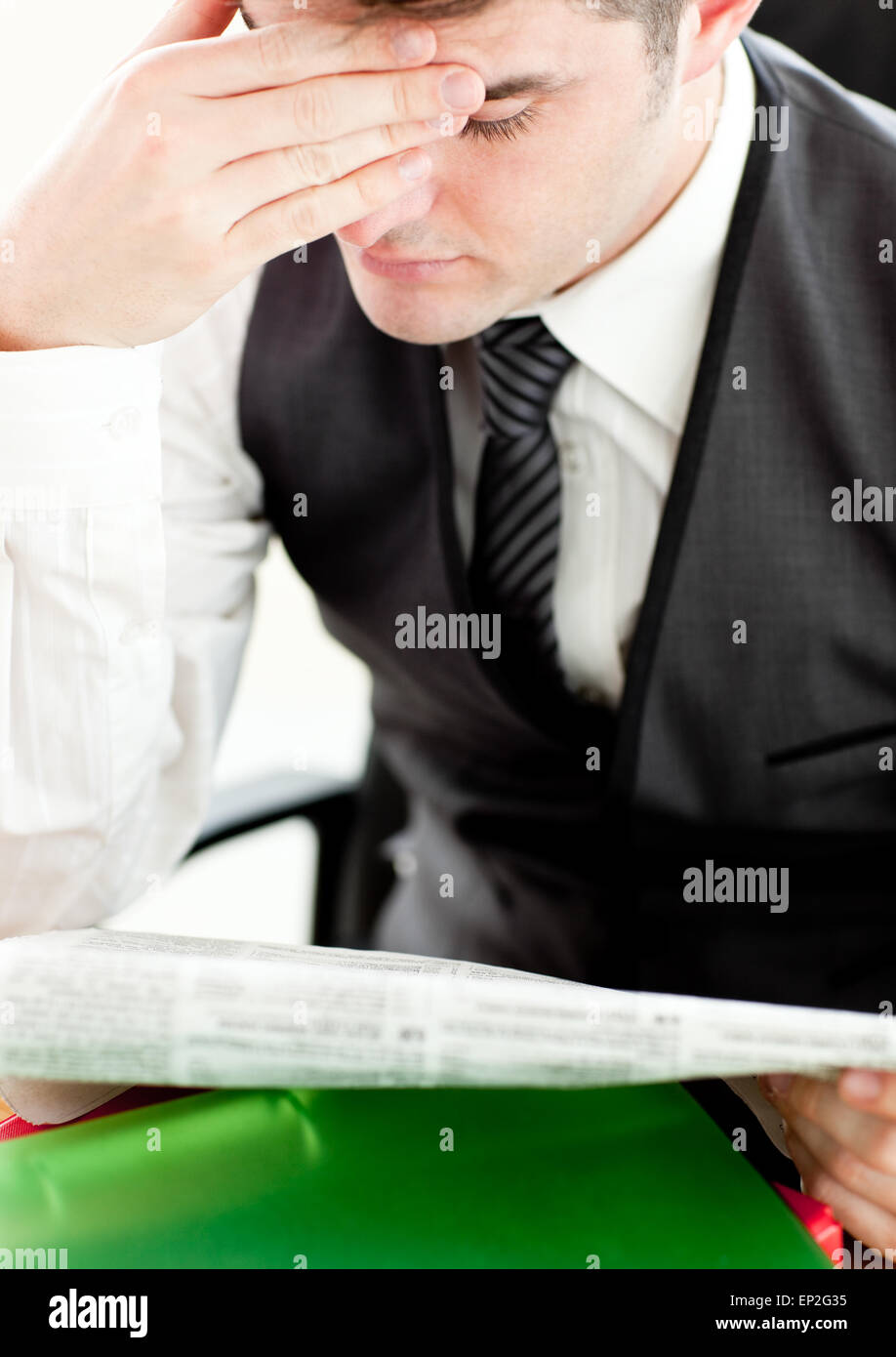 Thinking businessman reading a newspaper Stock Photo - Alamy