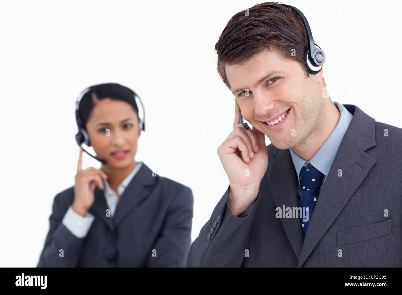 Close up of smiling call center agent with co-worker behind him Stock ...