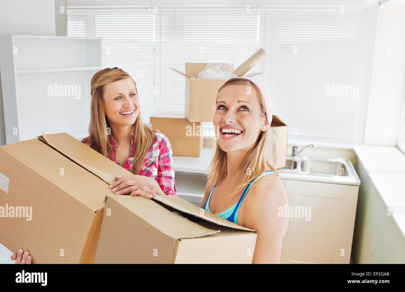 Two radiant women carrying boxes at home Stock Photo - Alamy