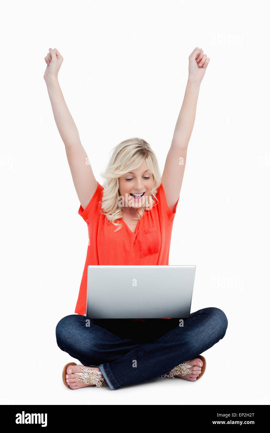 Young woman raising her arms in success in front of her laptop Stock ...
