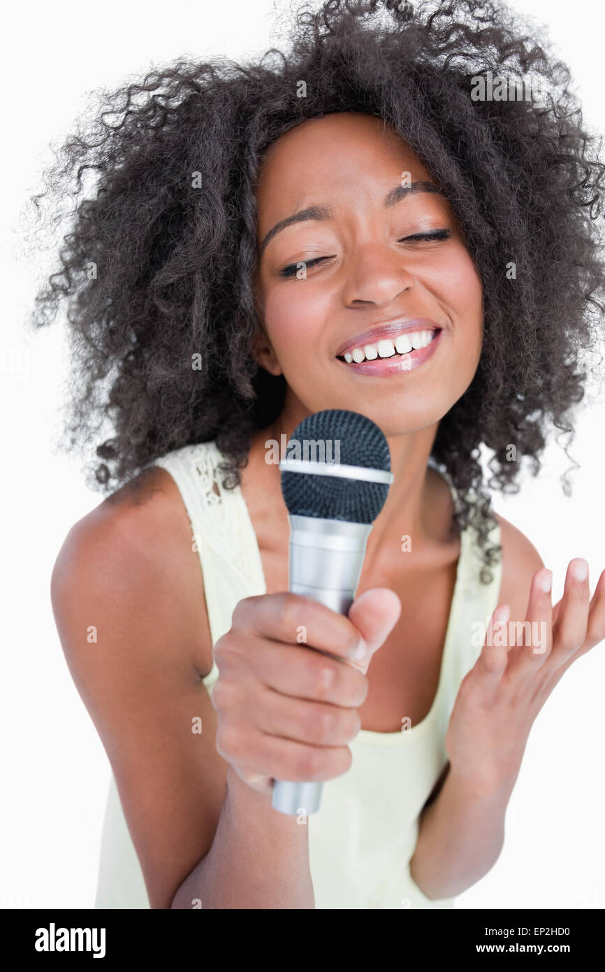 Concentrated young woman singing into a microphone Stock Photo - Alamy