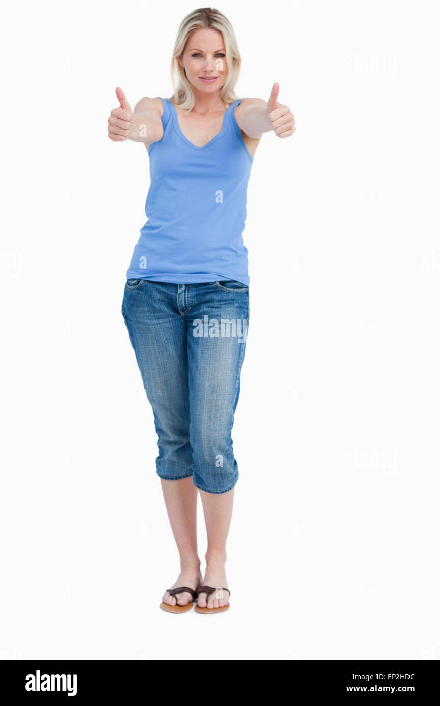 Blonde woman standing upright while placing her thumbs up Stock Photo ...