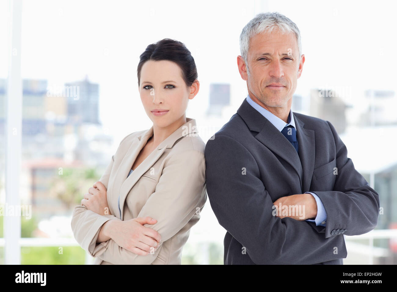 Business people standing upright in front of the window side by side ...