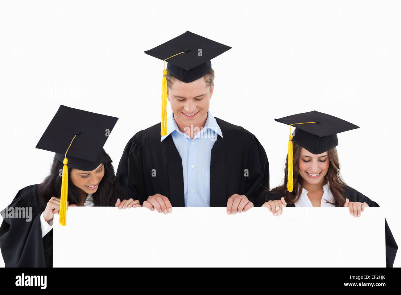 Three students having graduated holding blank sheet and looking at it ...
