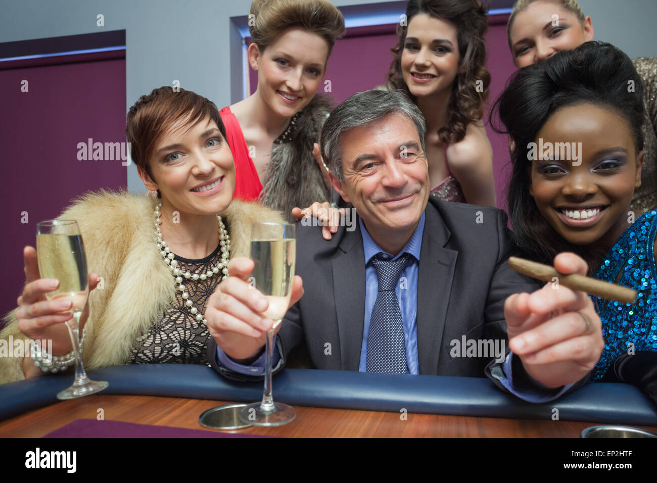 Happy man surrounded by women at roulette table Stock Photo - Alamy