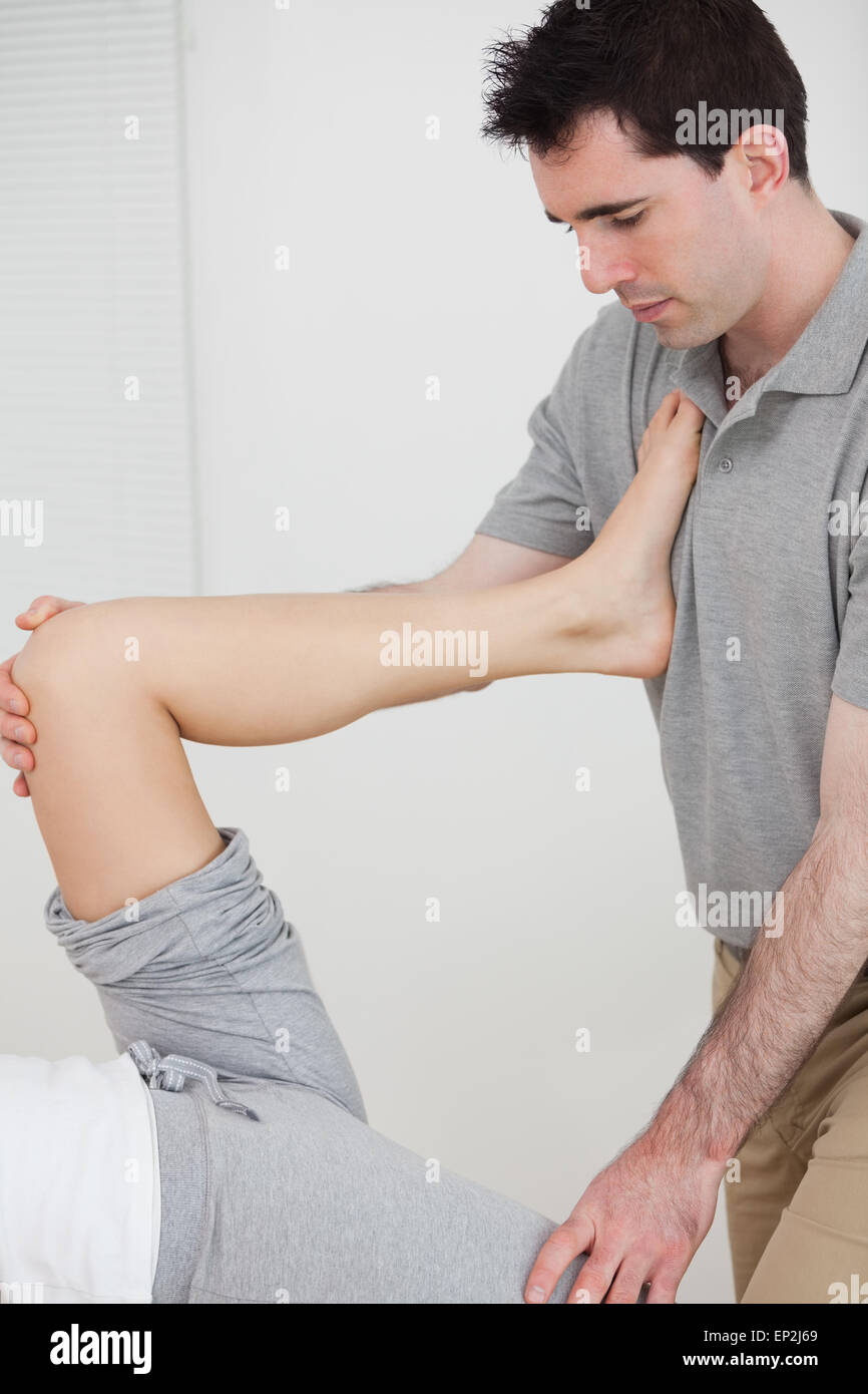 Physiotherapist stretching a leg while placed it on his chest Stock ...