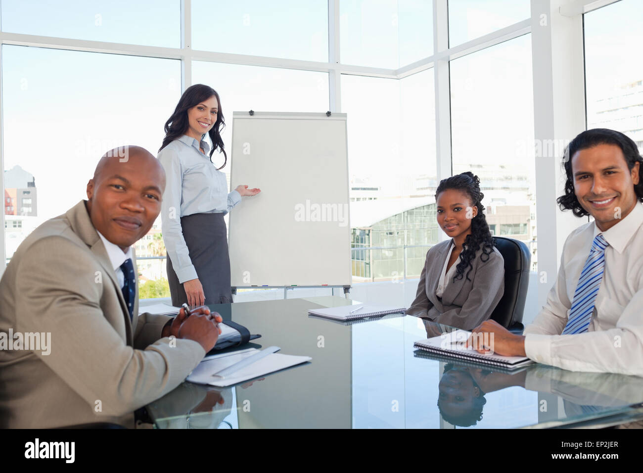 Smiling businesswoman giving a presentation to her relaxed colleagues ...