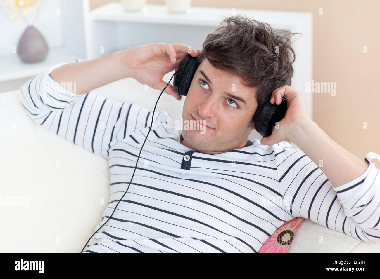 thoughful man listening music looking the top sitting in the sofa Stock ...