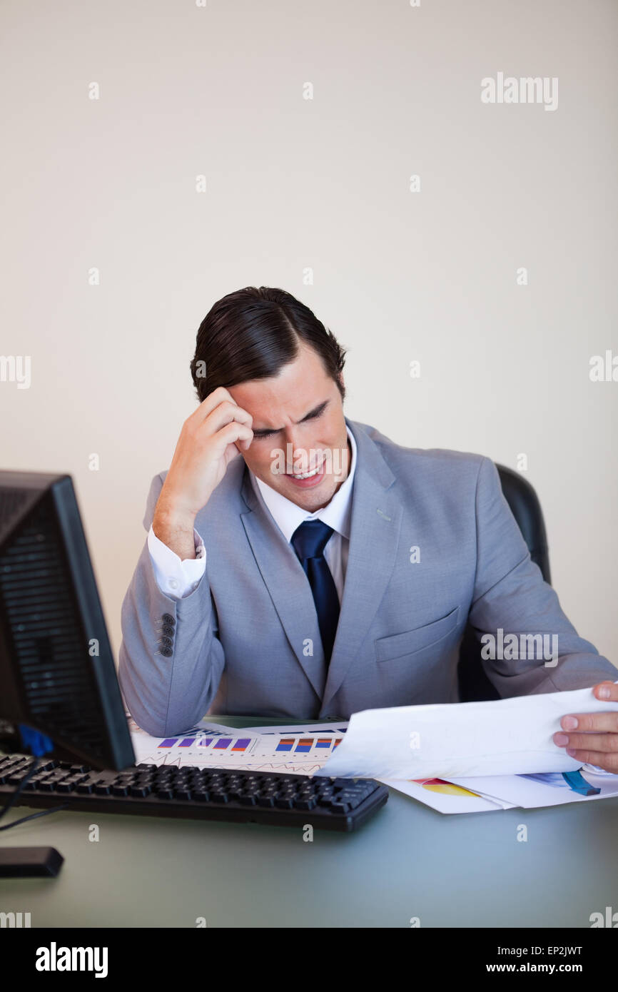 Businessman getting a headache from looking at paperwork Stock Photo ...